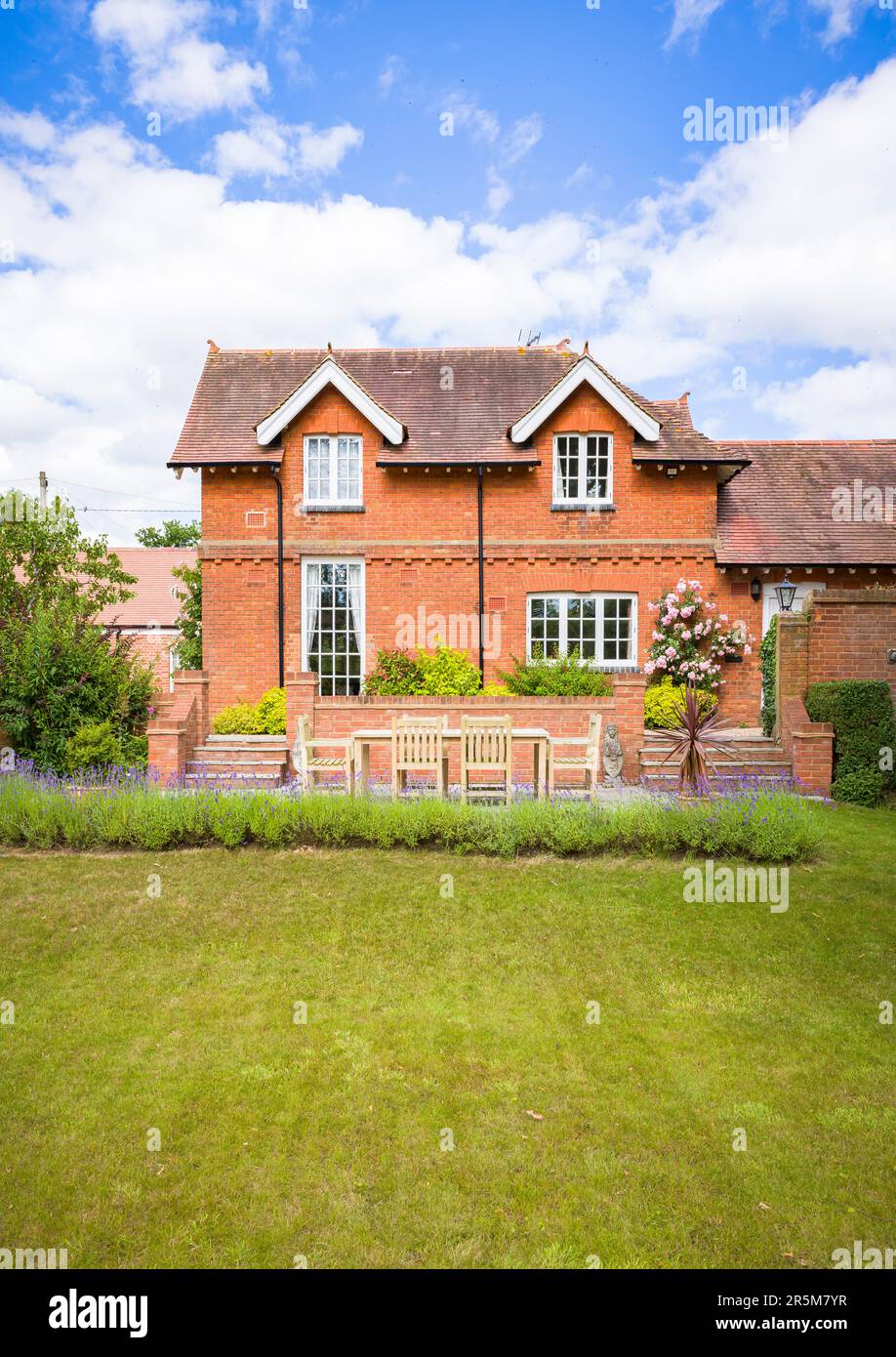 Large UK country house and garden in summer with lawn and patio terrace ...