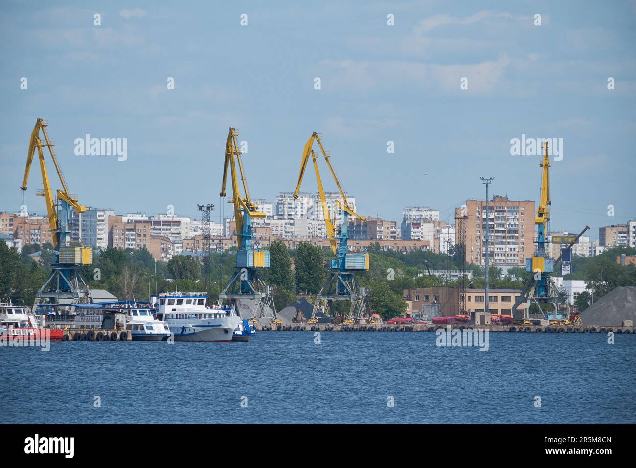 Working cranes for cargo in river port Stock Photo - Alamy