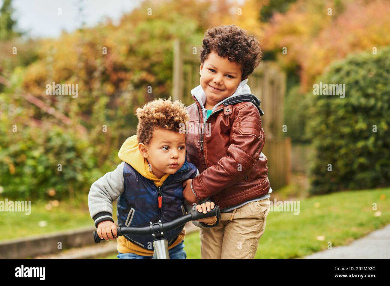 Portrait of two cute little brothers playing together outside on a nice ...