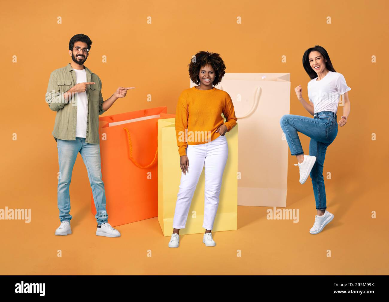 Happy multiethnic millennial people posing by big shopping bags Stock ...