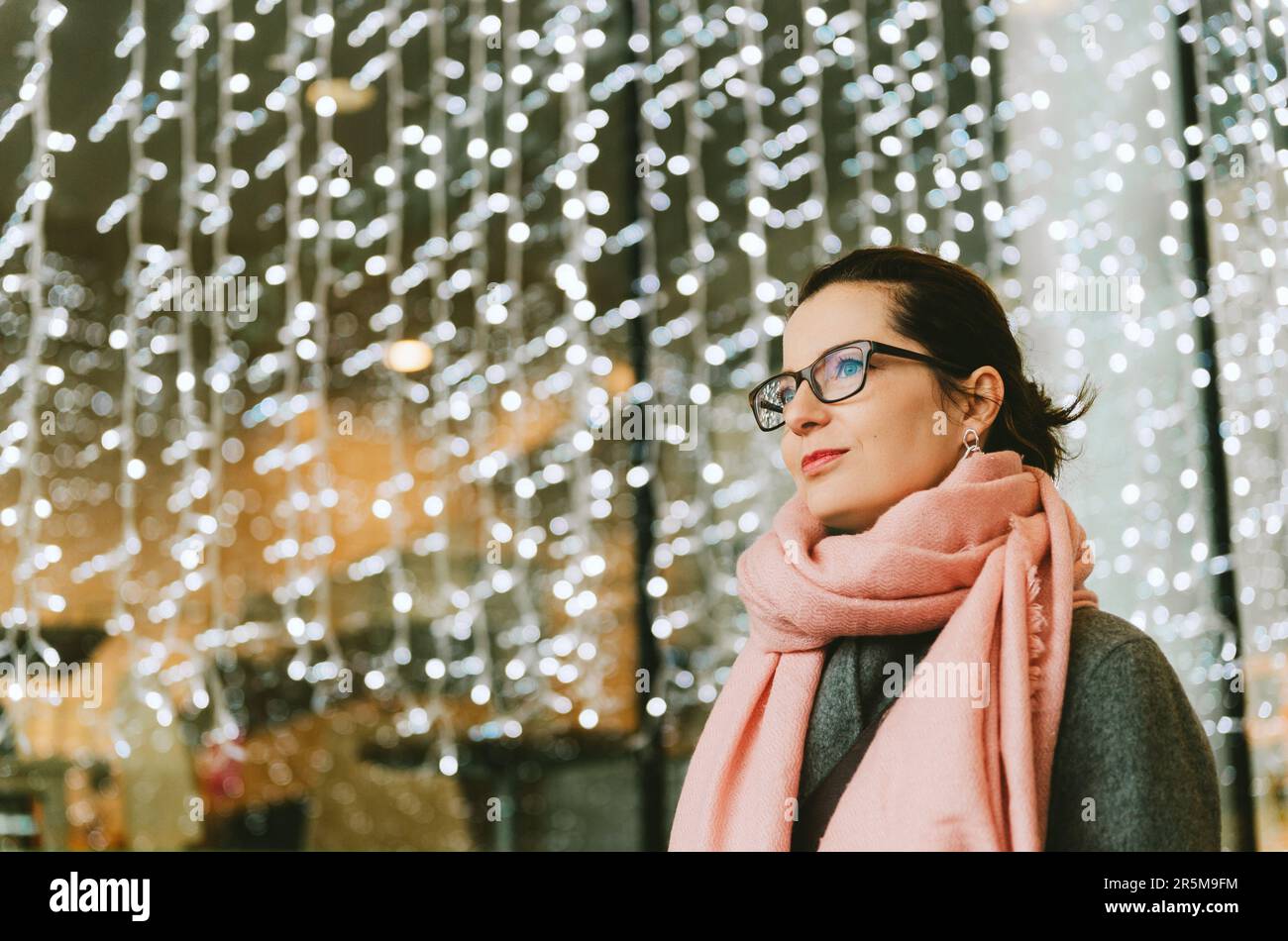 Outdoor portrait of beautiful woman posing ina city with many lights on ...