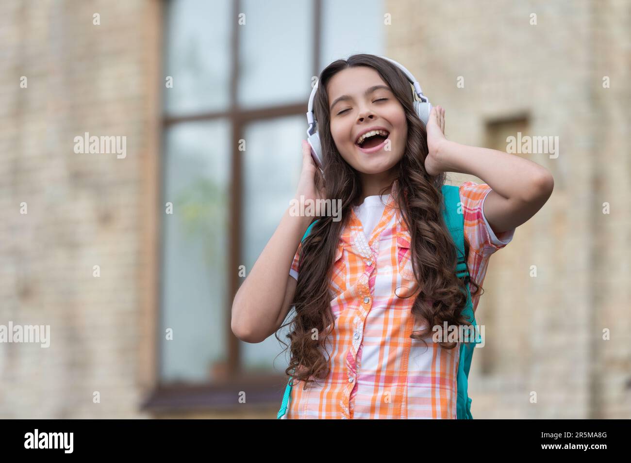 singing school girl listen music outside. photo of school girl listen ...