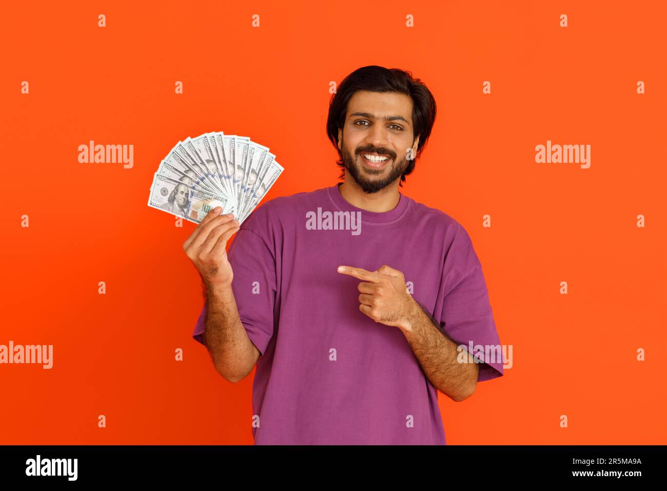 Cheerful eastern guy holding money cash in his hand Stock Photo - Alamy