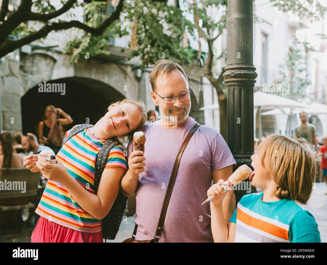 Happy father with children eating ice cream outdoors, family time ...