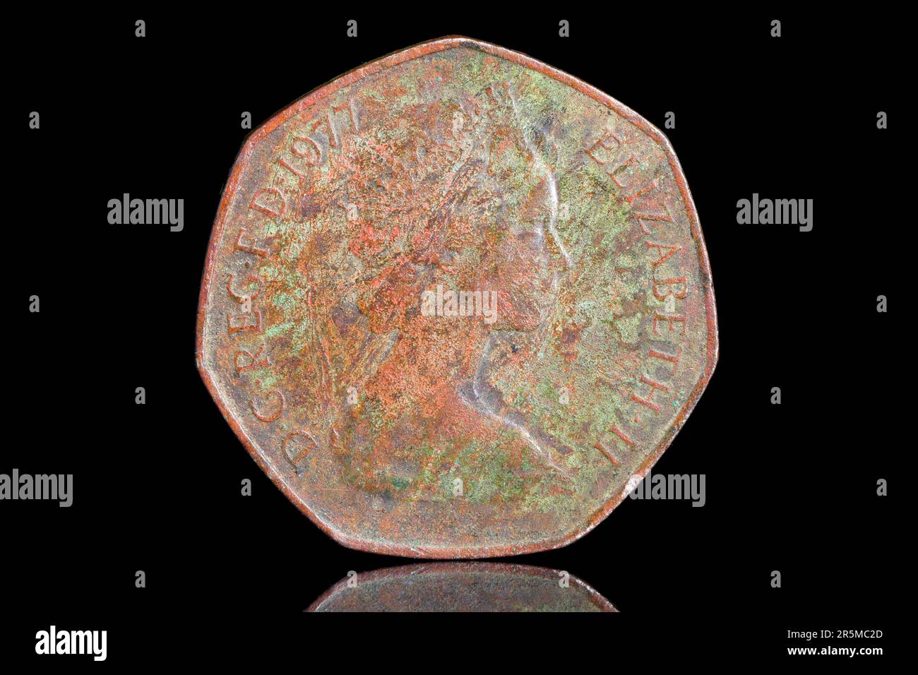 1977 50 pence coin that is dirty and has oxidized through wear and tear ...