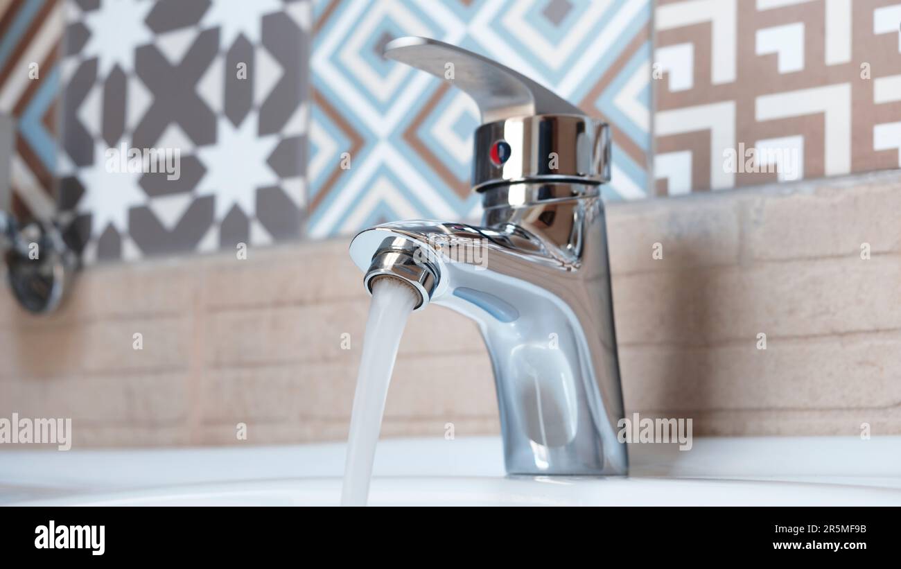 Faucet and water drop close up. Bathroom interior with sink and water ...