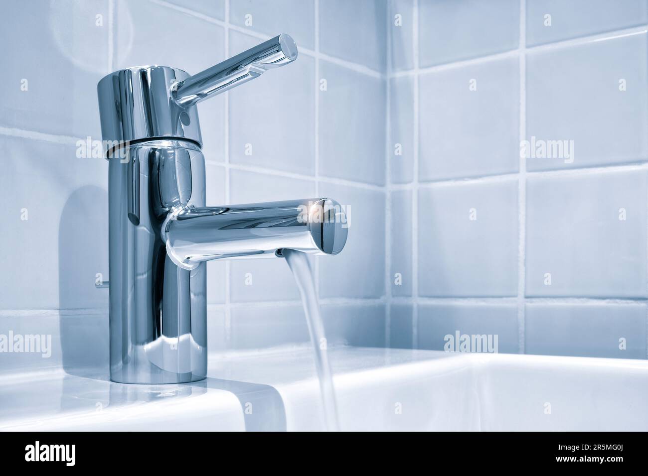 Faucet and water drop close up. Bathroom interior with sink and water ...