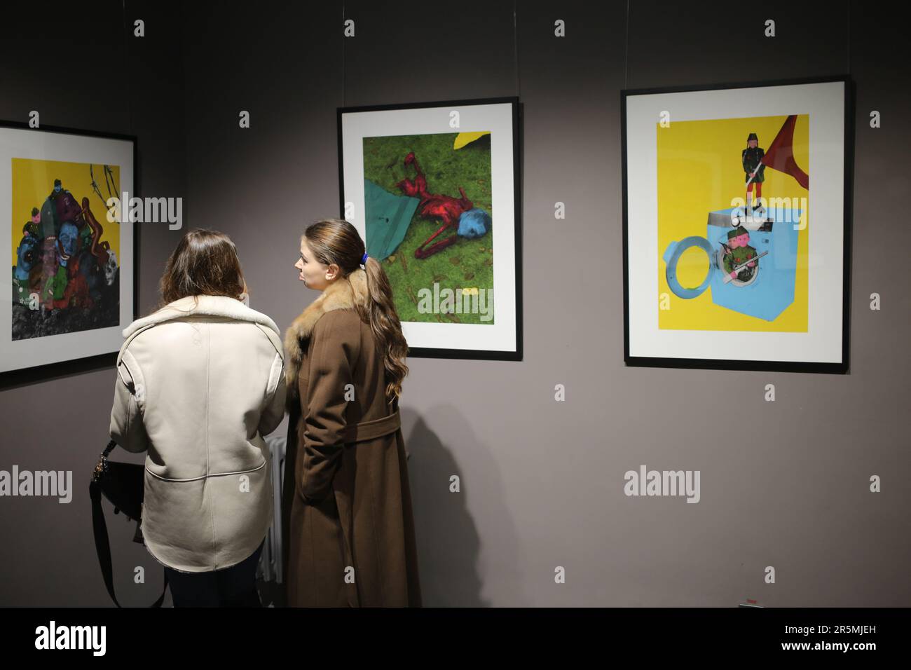 People are seen looking at digital collages by Igor Hora from the ...