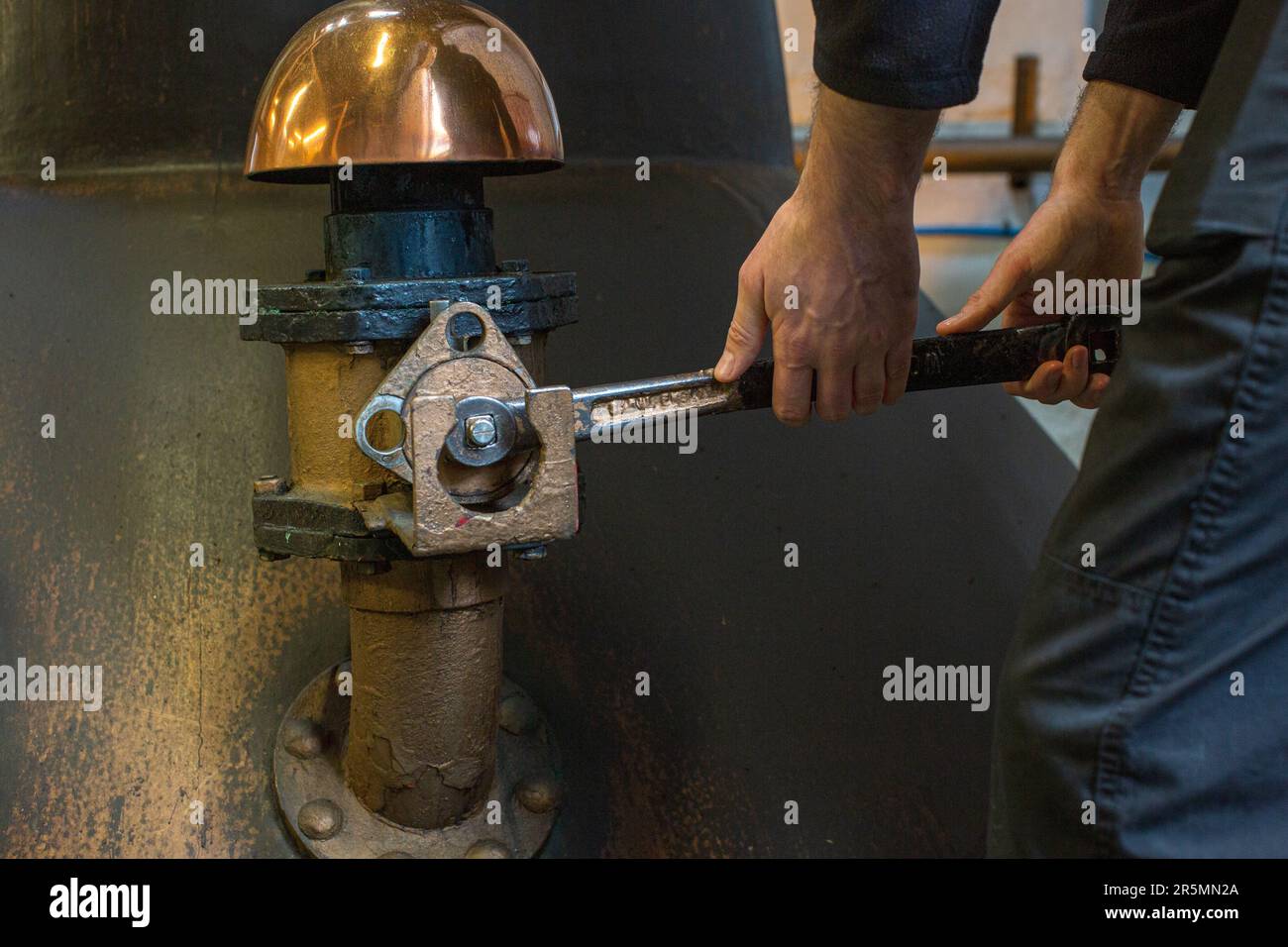 Distillery operator control heat flow and pressure at copper pot still ...