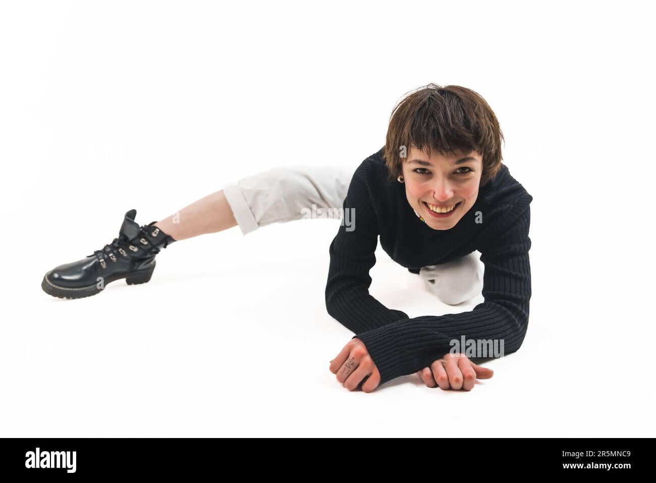 Full shot of a female model leaning forward on her elbows with one leg ...