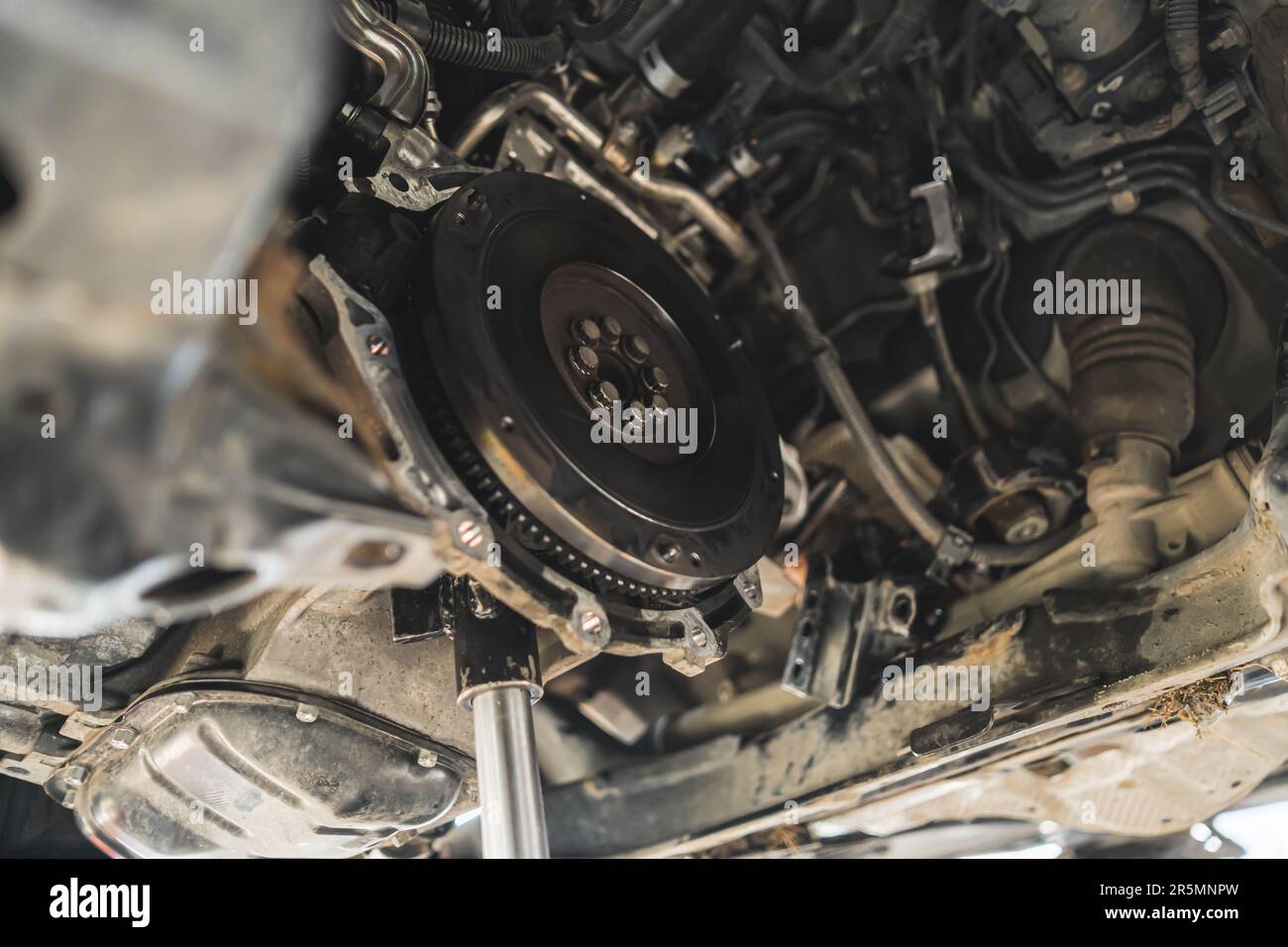A car on a lift in repair service, the gearbox removed, with visible ...