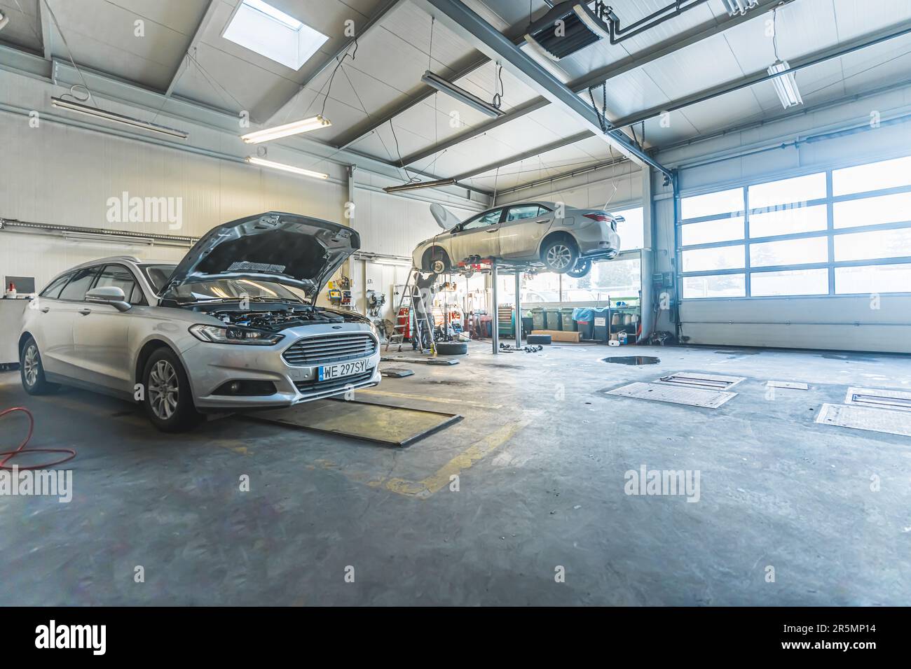 Inside of a car body repair shop with vehicles being fixed, car maintenance service. High ...