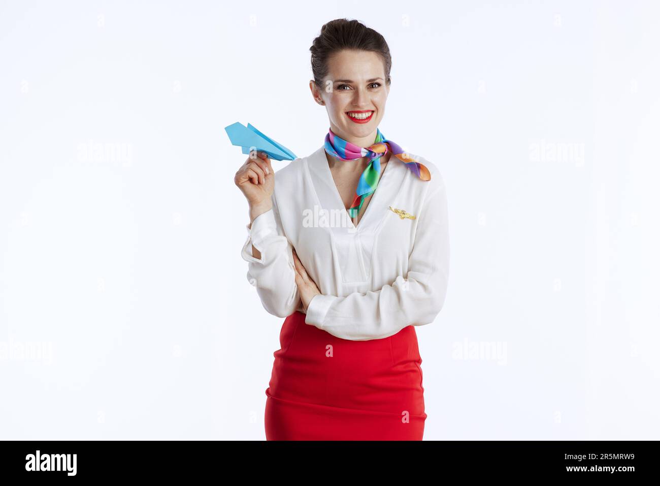 smiling stylish female flight attendant against white background in ...