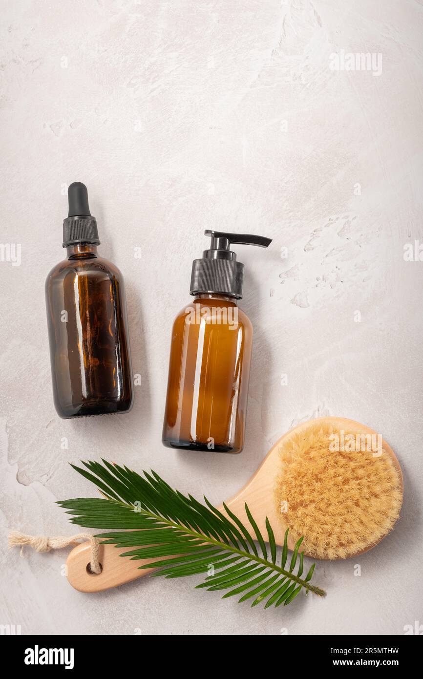 Bottles of dark amber glass with essential oil, massage brush and ...