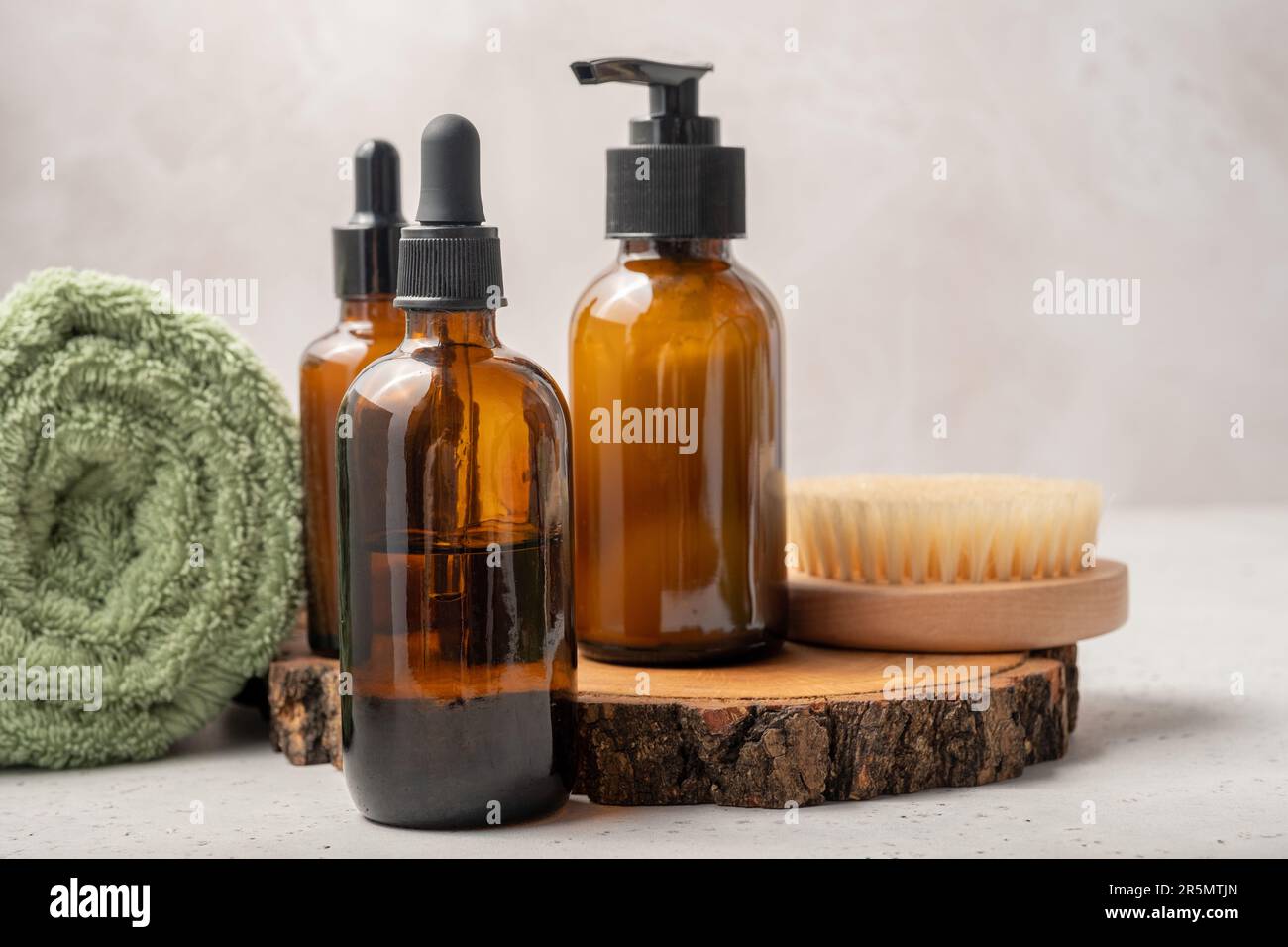 Bottles of dark amber glass with essential oil, massage brush and ...