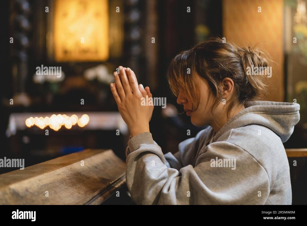 Woman praying on her knees in an ancient Catholic temple to God Stock ...