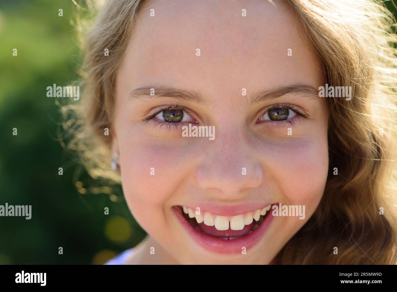 Cute little smiling happy girl close up face. Outdoor closeup portrait ...
