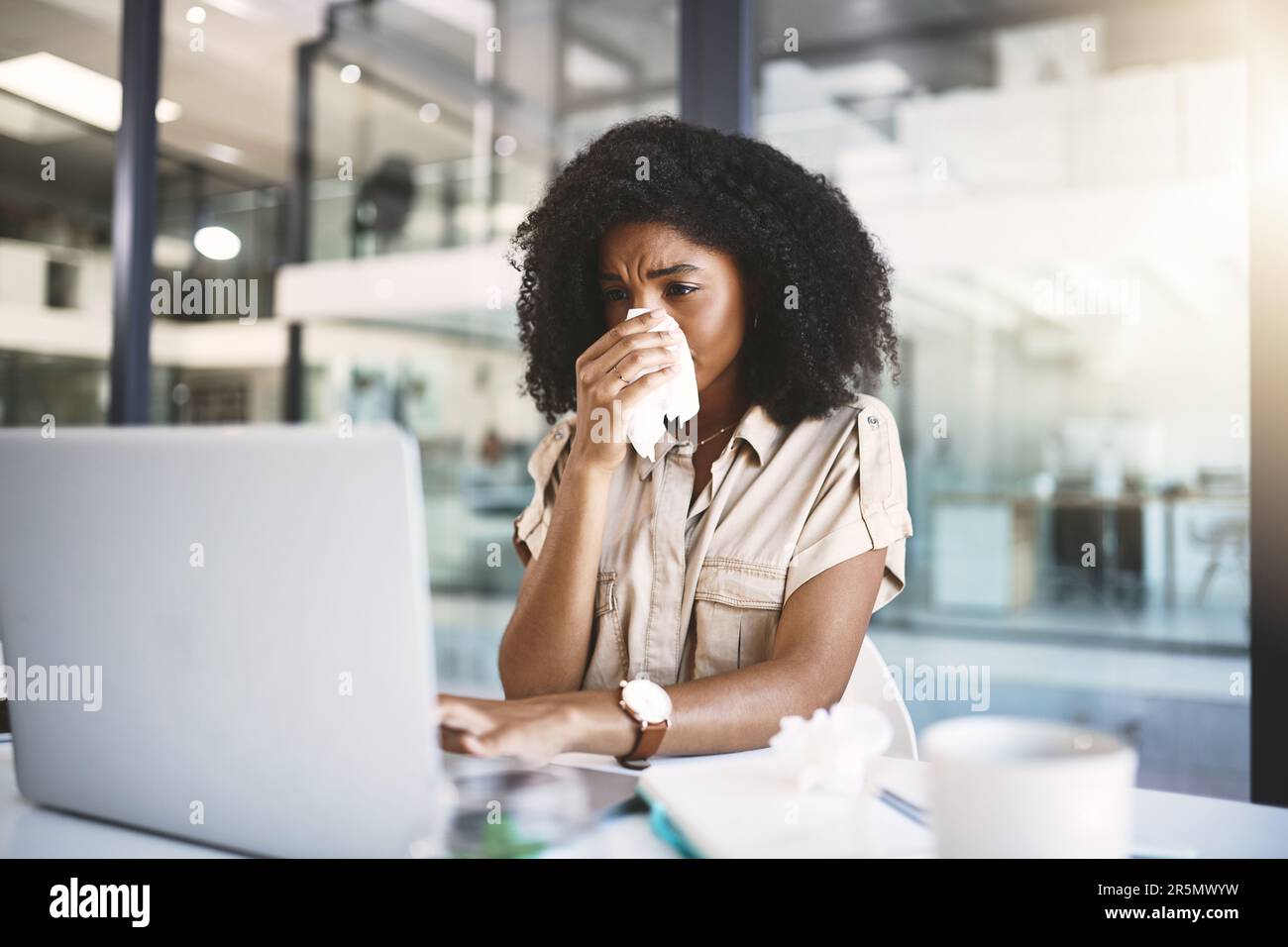 Flu can wait, theres work to do. a young businesswoman blowing her nose ...