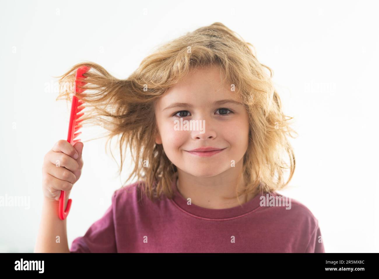Boy brushes his hair. Little kid combing hair, isolated studio ...