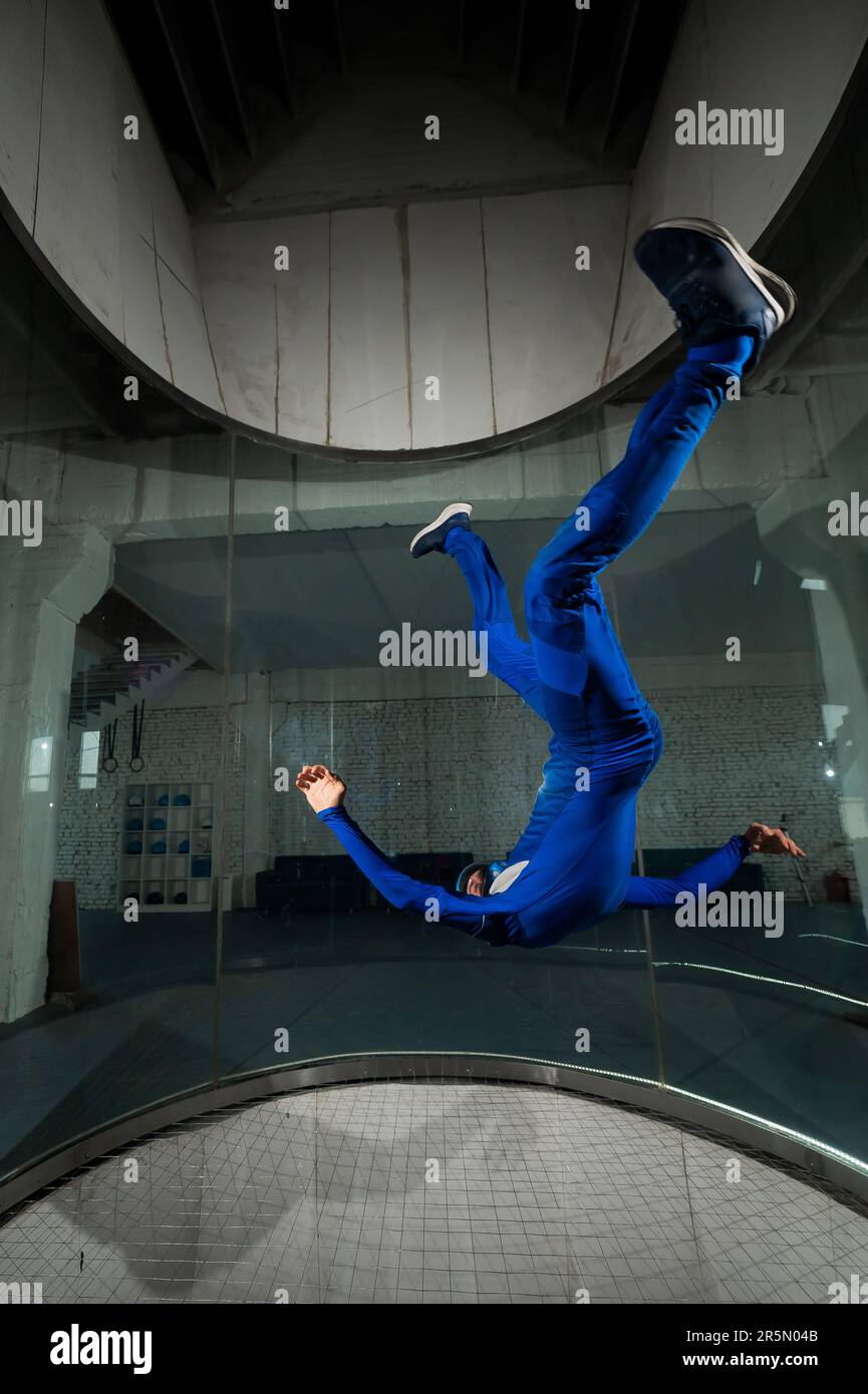 A man in overalls and a protective helmet enjoys flying in a wind ...
