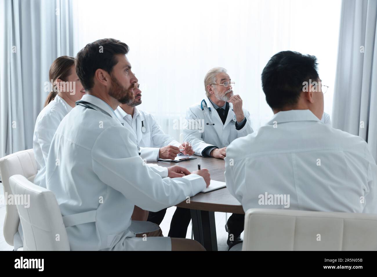 Team of doctors watching presentation in room. Medical conference Stock ...