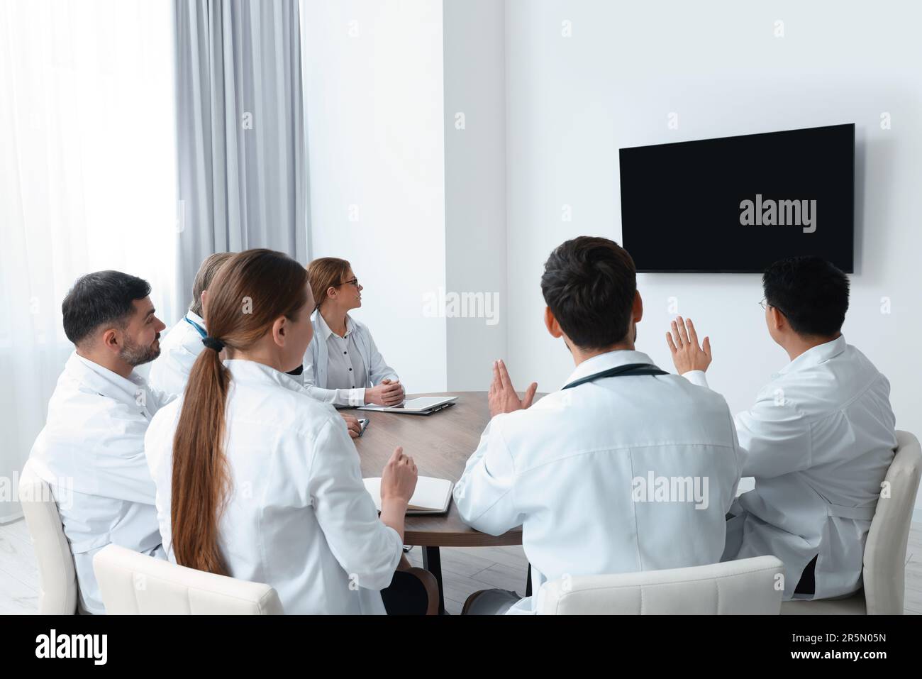 Team of doctors watching presentation on tv screen in room. Medical ...