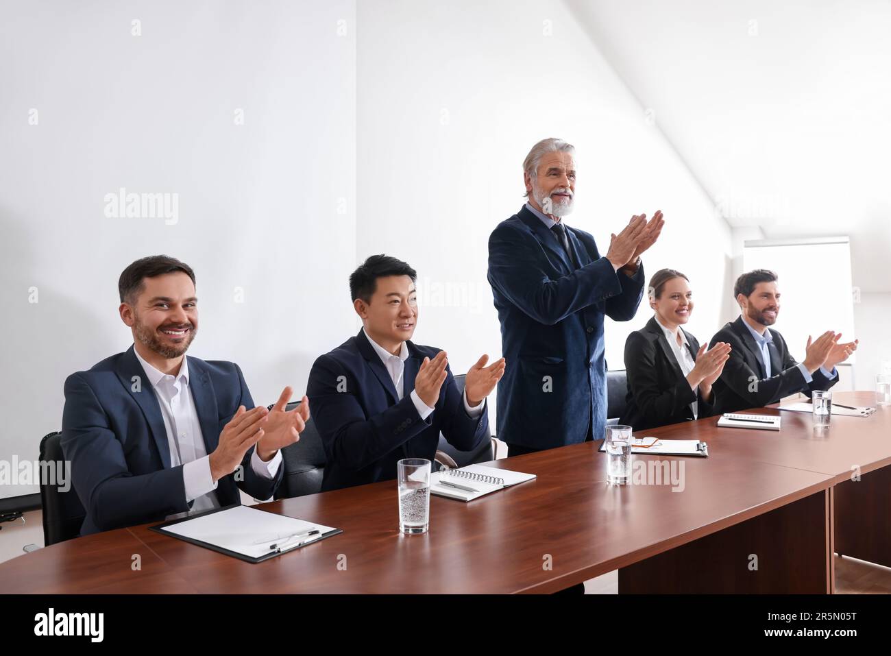 Business conference. People in meeting room applauding to speaker ...