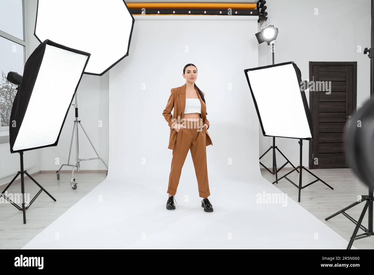 Beautiful young model posing in modern studio. Professional photo ...