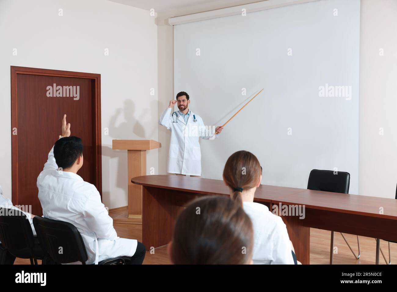 Doctor giving lecture in conference room with projection screen Stock ...