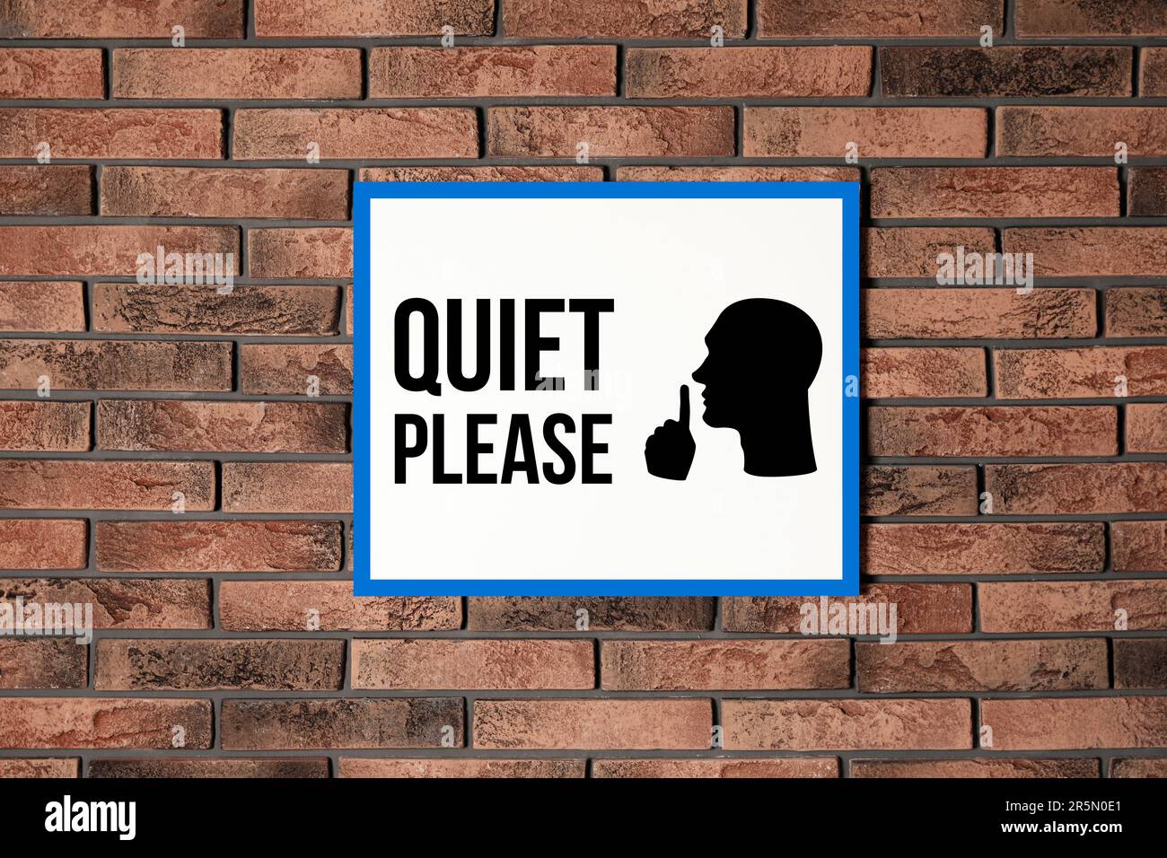 Quiet Please sign with shush gesture image on red brick wall Stock ...