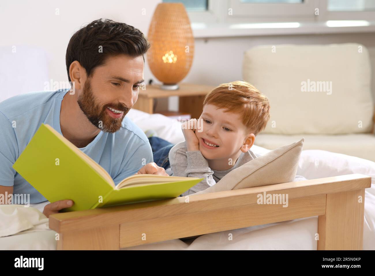 Father reading book with his child on bed at home Stock Photo - Alamy