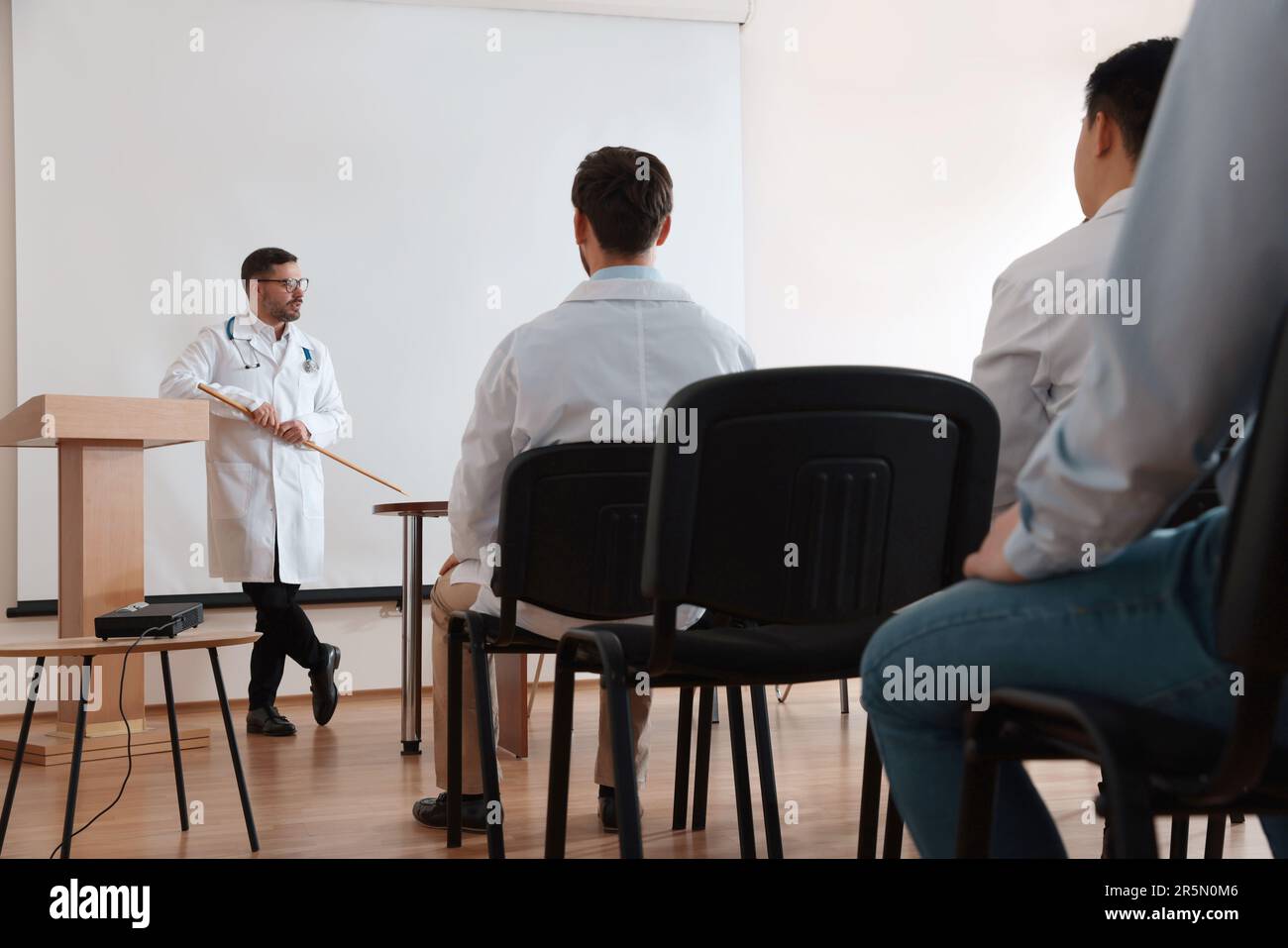 Doctor giving lecture in conference room with projection screen Stock ...