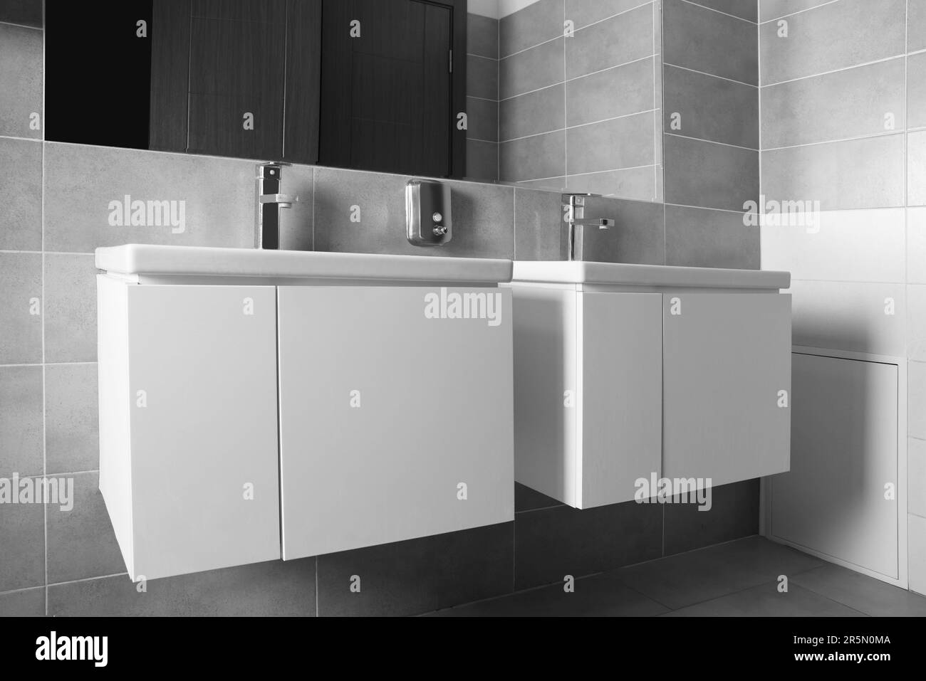 Beautiful clean sinks near mirror in public toilet Stock Photo - Alamy
