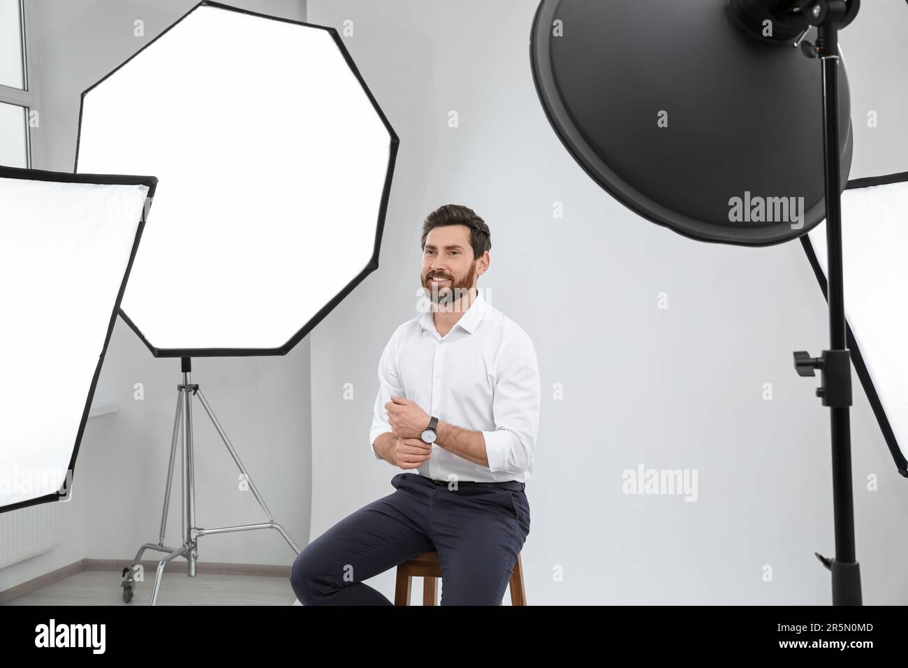 Handsome model posing in modern studio. Professional photo session ...