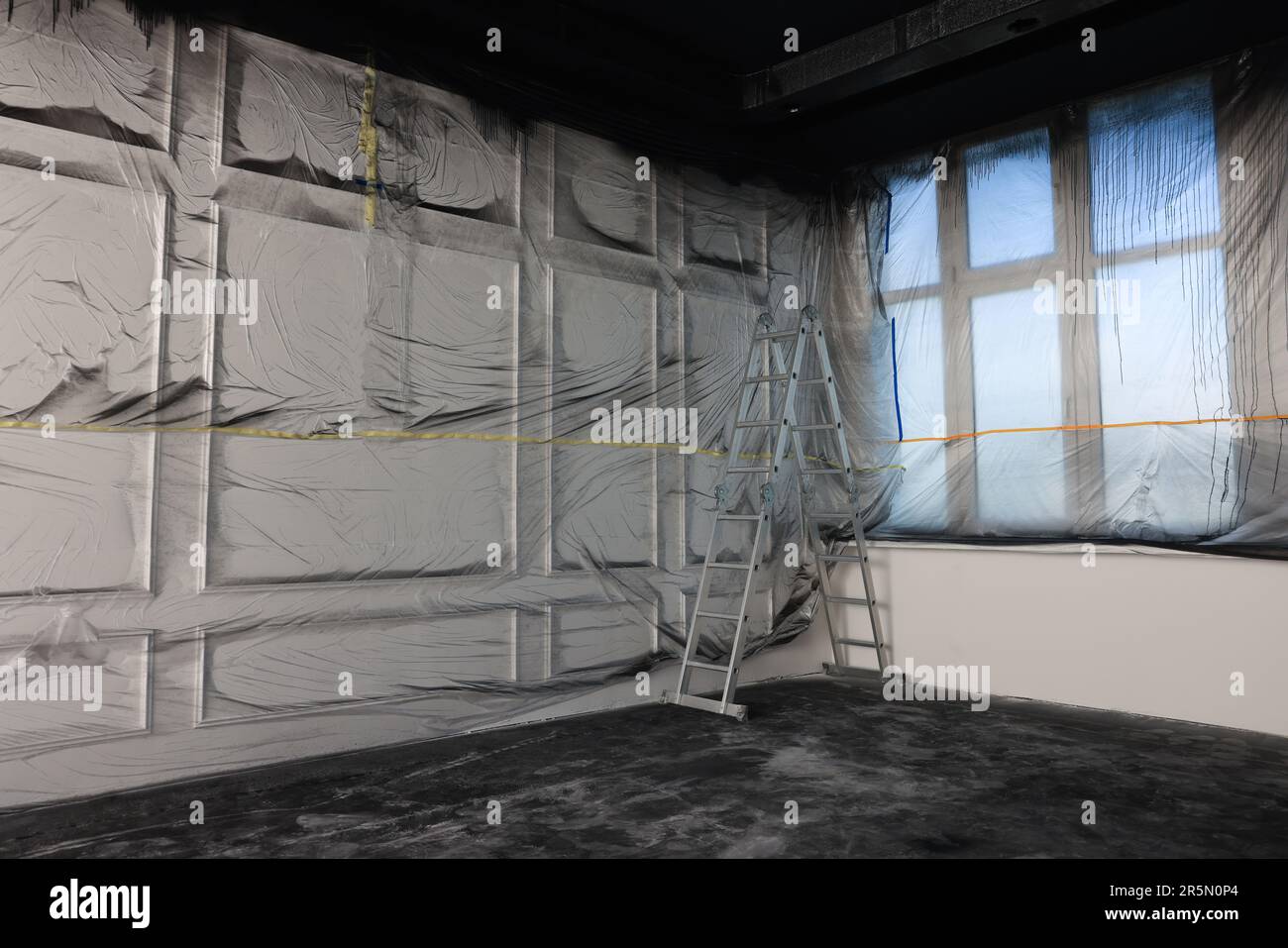 Windows and wall covered with polyethylene film. Protection during ...
