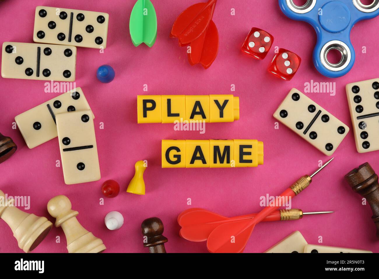 Flat lay composition of blocks with words Play Game on pink background ...
