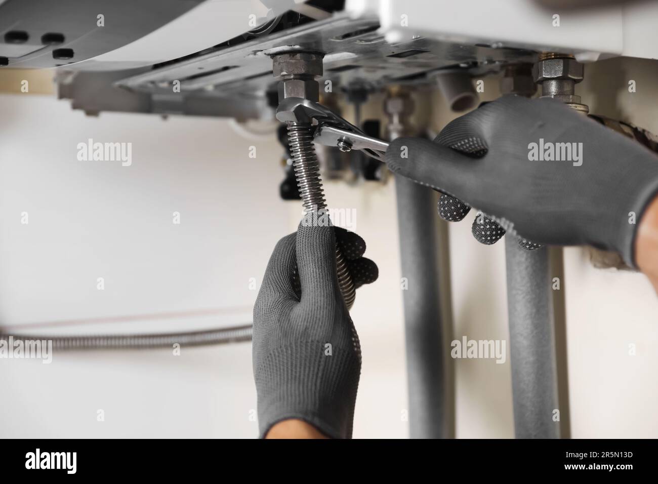 Man repairing gas boiler with waterpump plier, closeup Stock Photo - Alamy