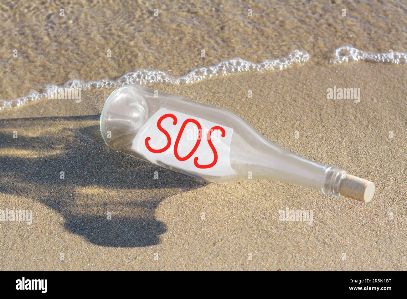 Glass bottle with SOS message on sand near sea Stock Photo - Alamy