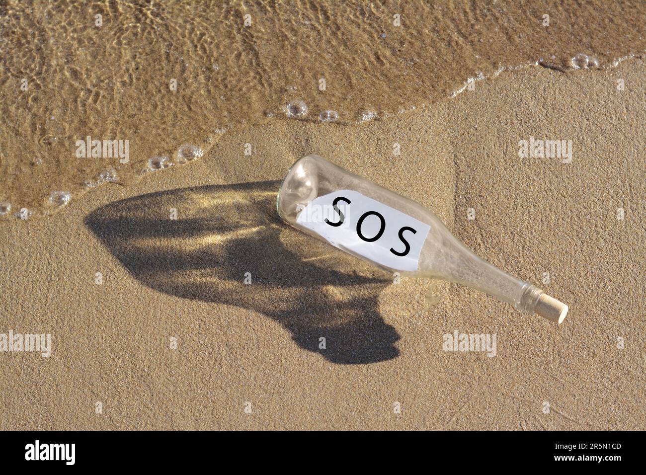 Glass bottle with SOS message on sand near sea Stock Photo - Alamy