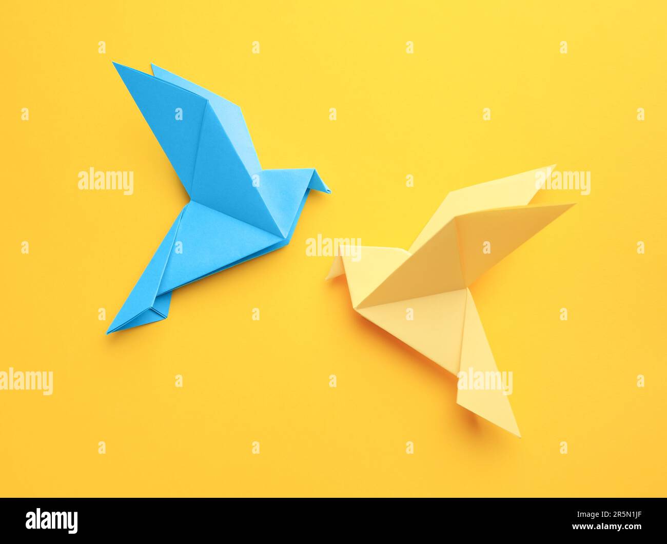Origami art. Colorful handmade paper birds on yellow background, flat ...