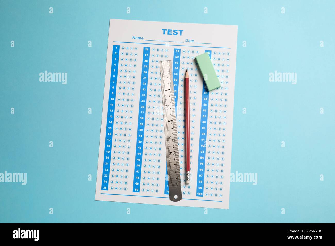 Answer sheet, pencil and ruler on light blue background, top view ...