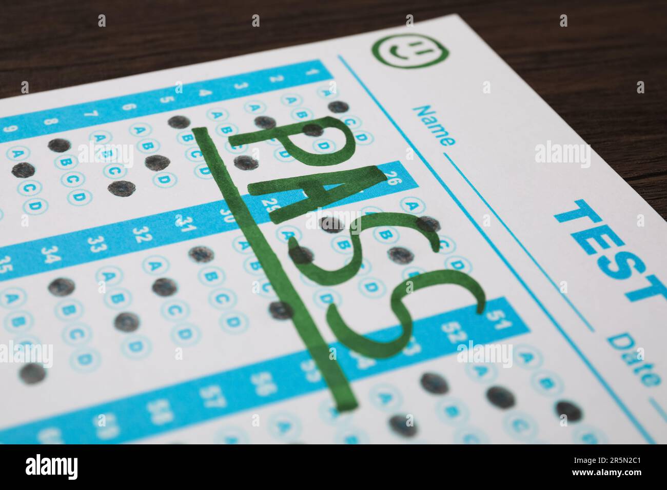 Answer sheet with word Pass on wooden table, closeup. Student passing ...
