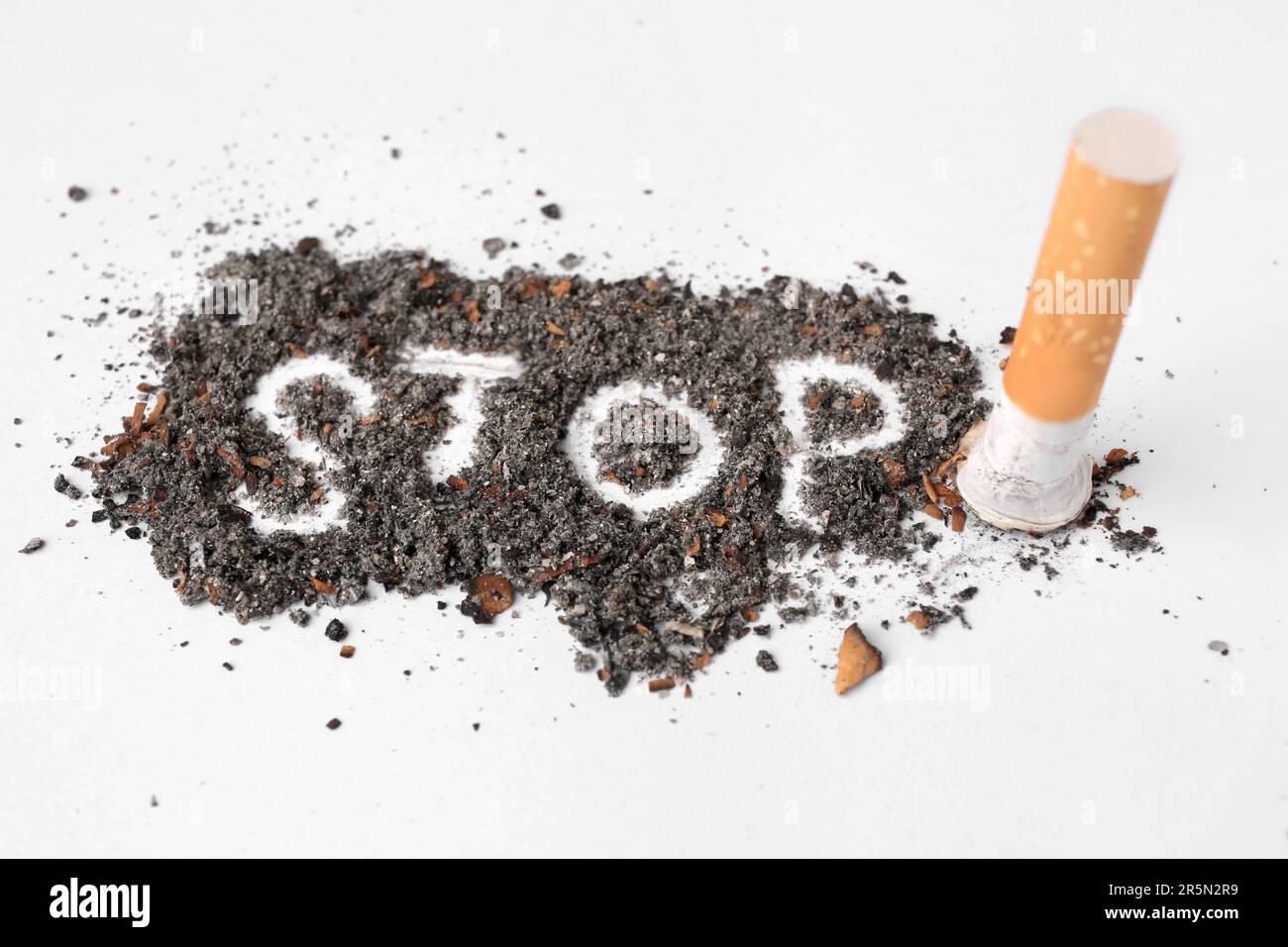 Word Stop made of cigarette ash and stub on white background, closeup ...