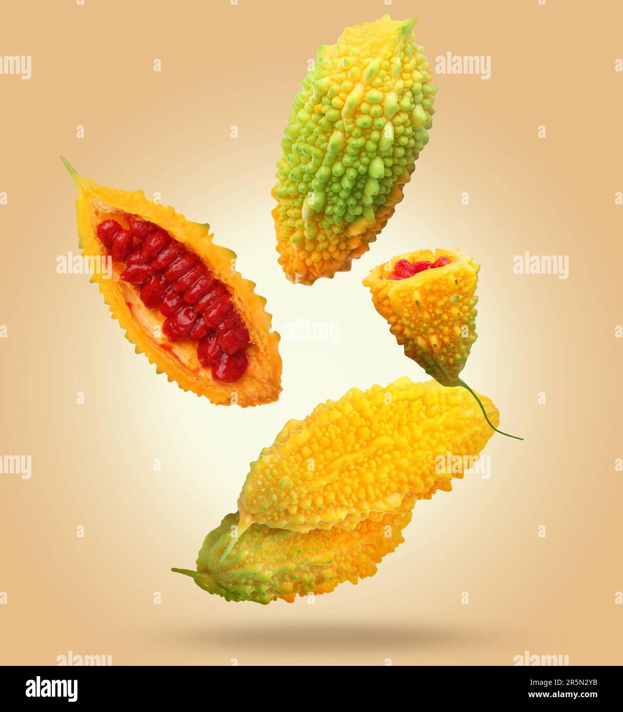 Delicious ripe bitter melons falling on beige background Stock Photo ...