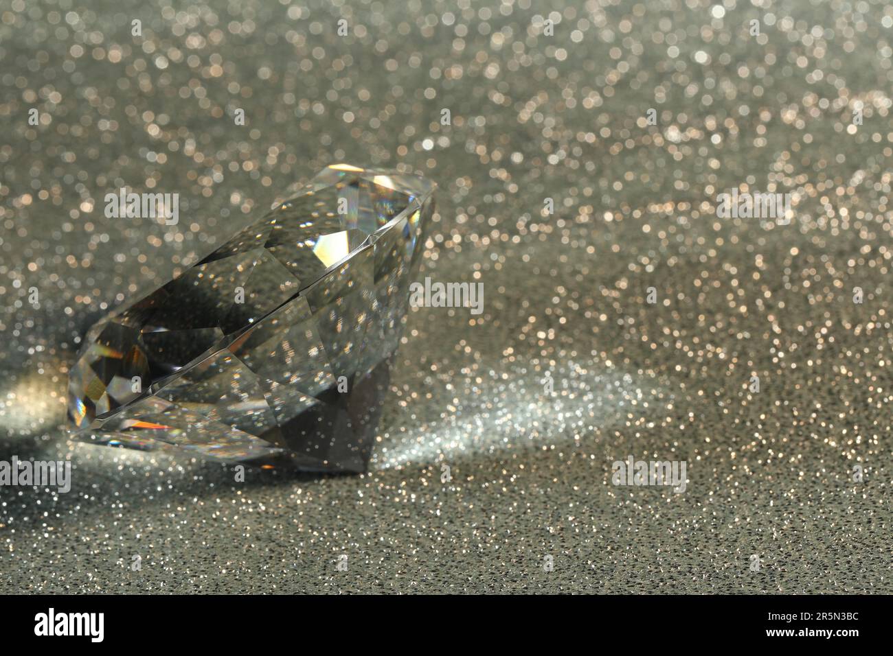 Beautiful dazzling diamond on glitter background, closeup. Space for ...