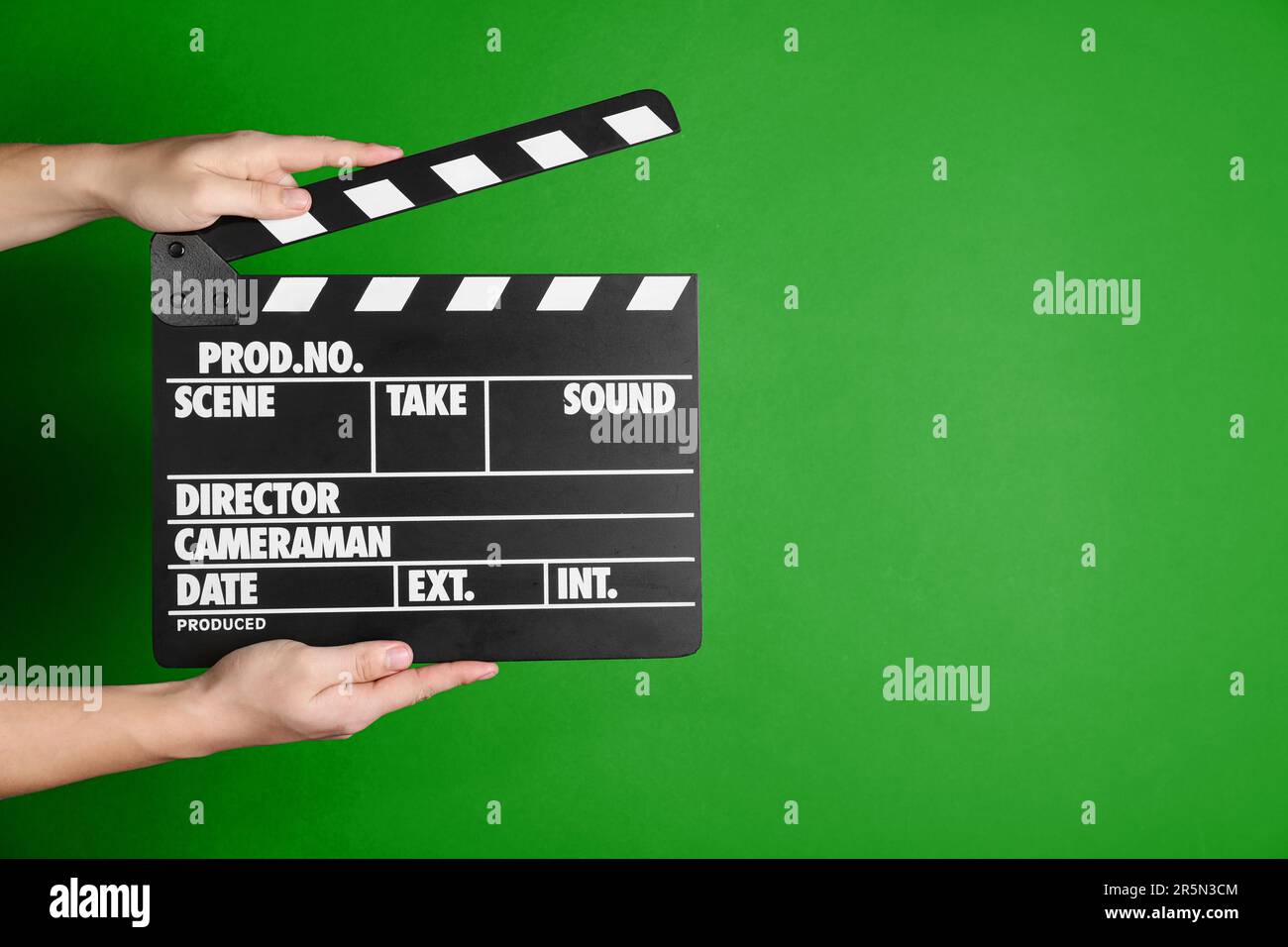 Second assistant camera holding clapper board against chroma key ...