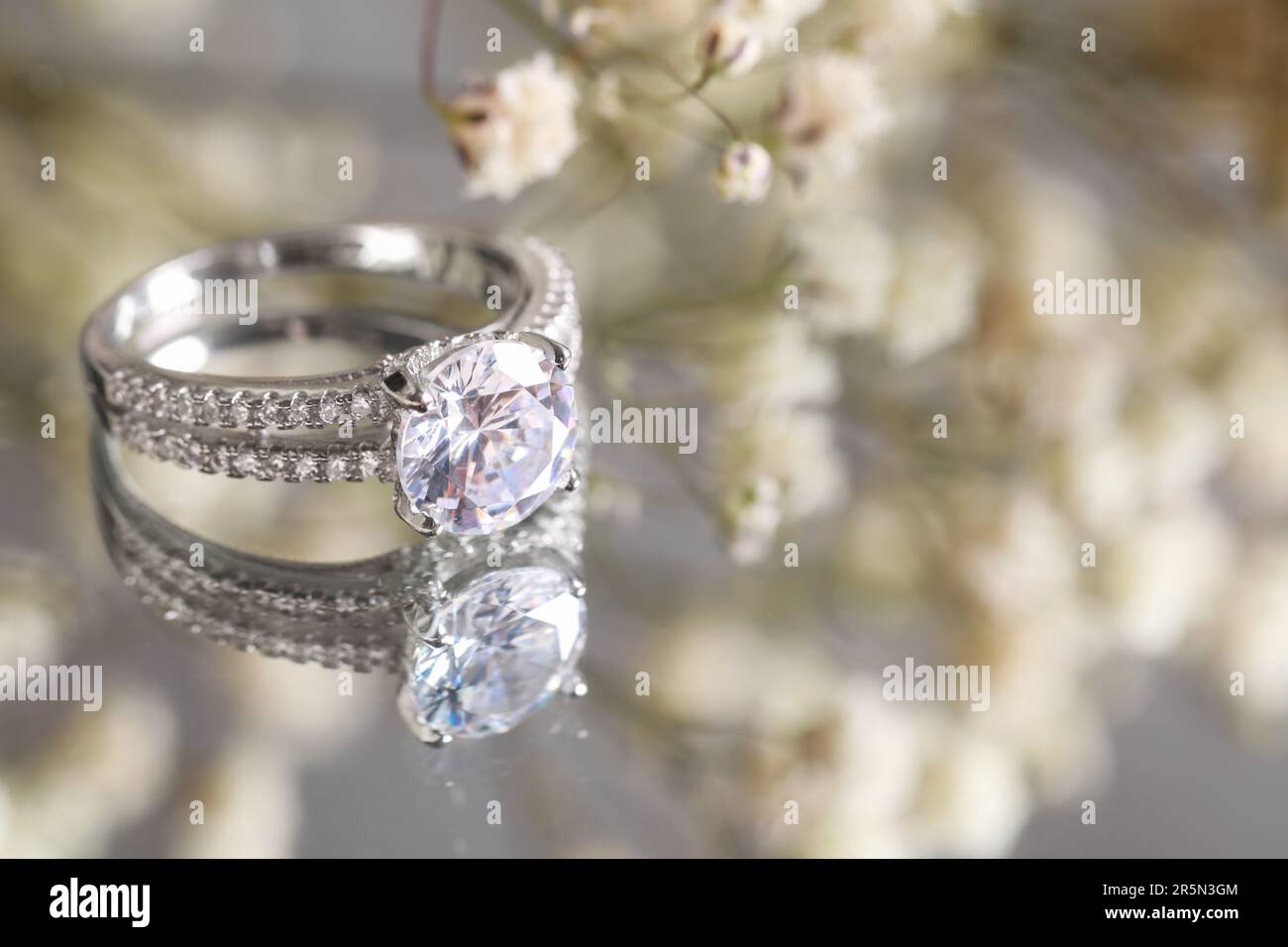 Elegant jewelry. Stylish presentation of luxury ring on mirror, closeup ...