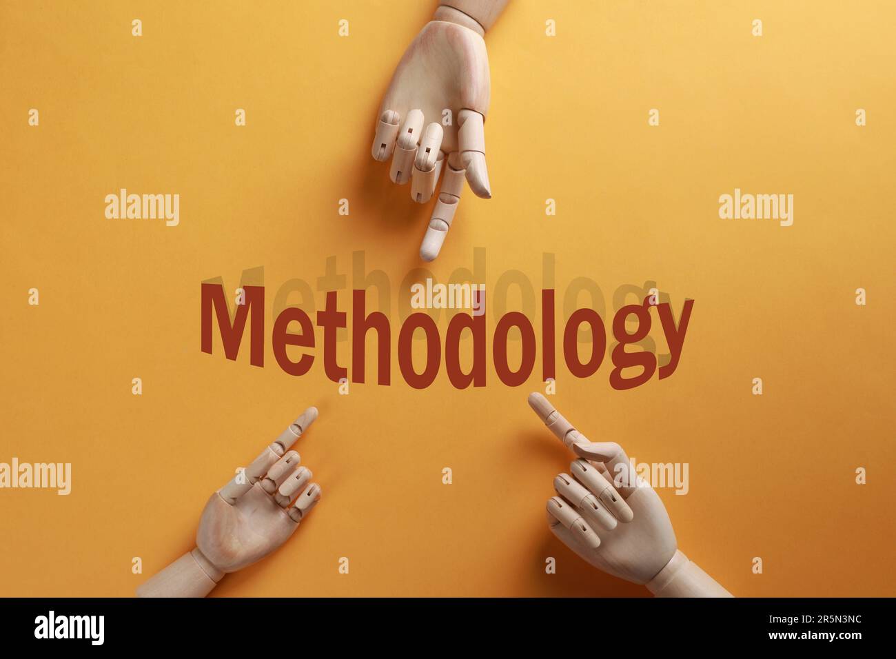 Wooden mannequin hands pointing at word Methodology on orange ...