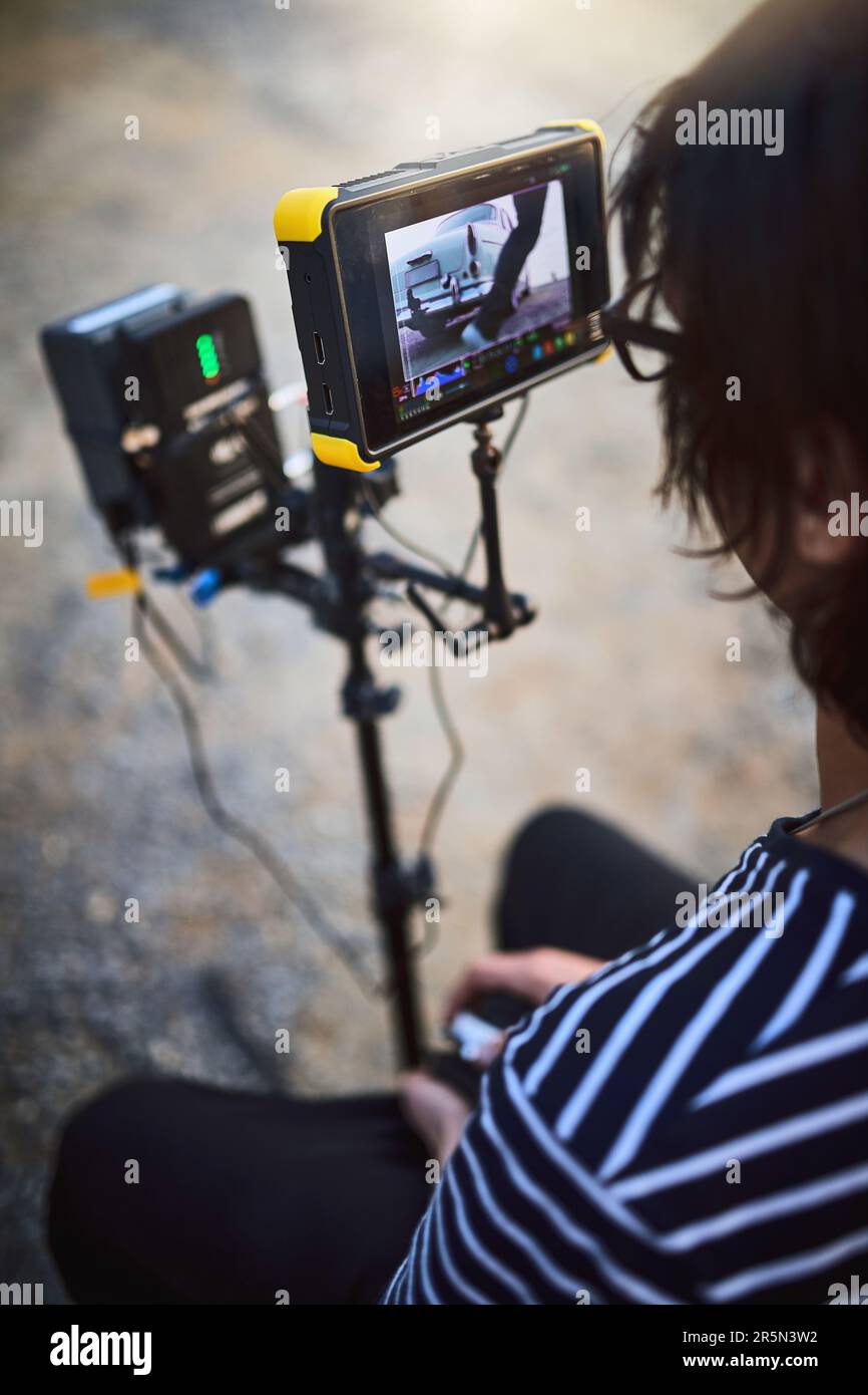 What do the screens show. Over the shoulder shot of a focused young man ...