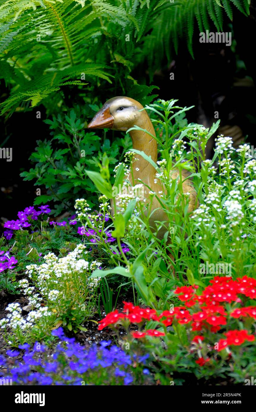 Garden figure: Ceramic goose in a flower garden Stock Photo - Alamy